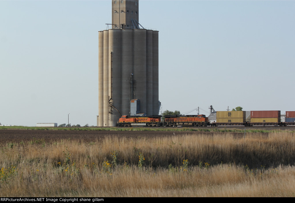 BNSF 6707 run dpu past the huge grain elevator in ks.